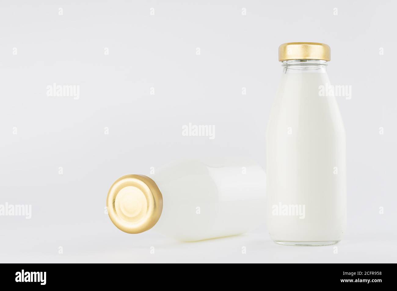 White milk product in glass bottles with empty cap for label mock up on ...