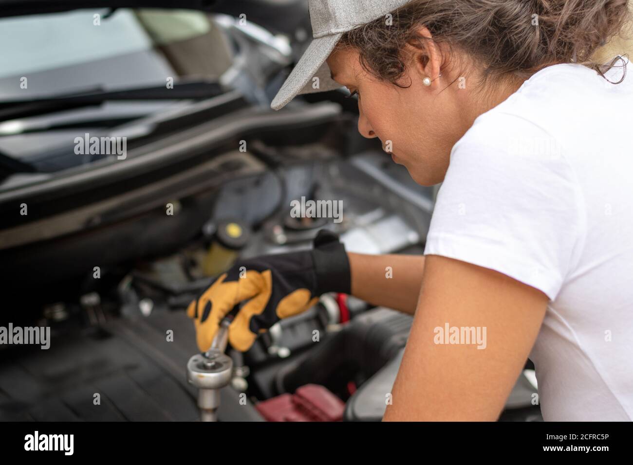 Woman work power. Female auto mechanic worker on car engine using a ...