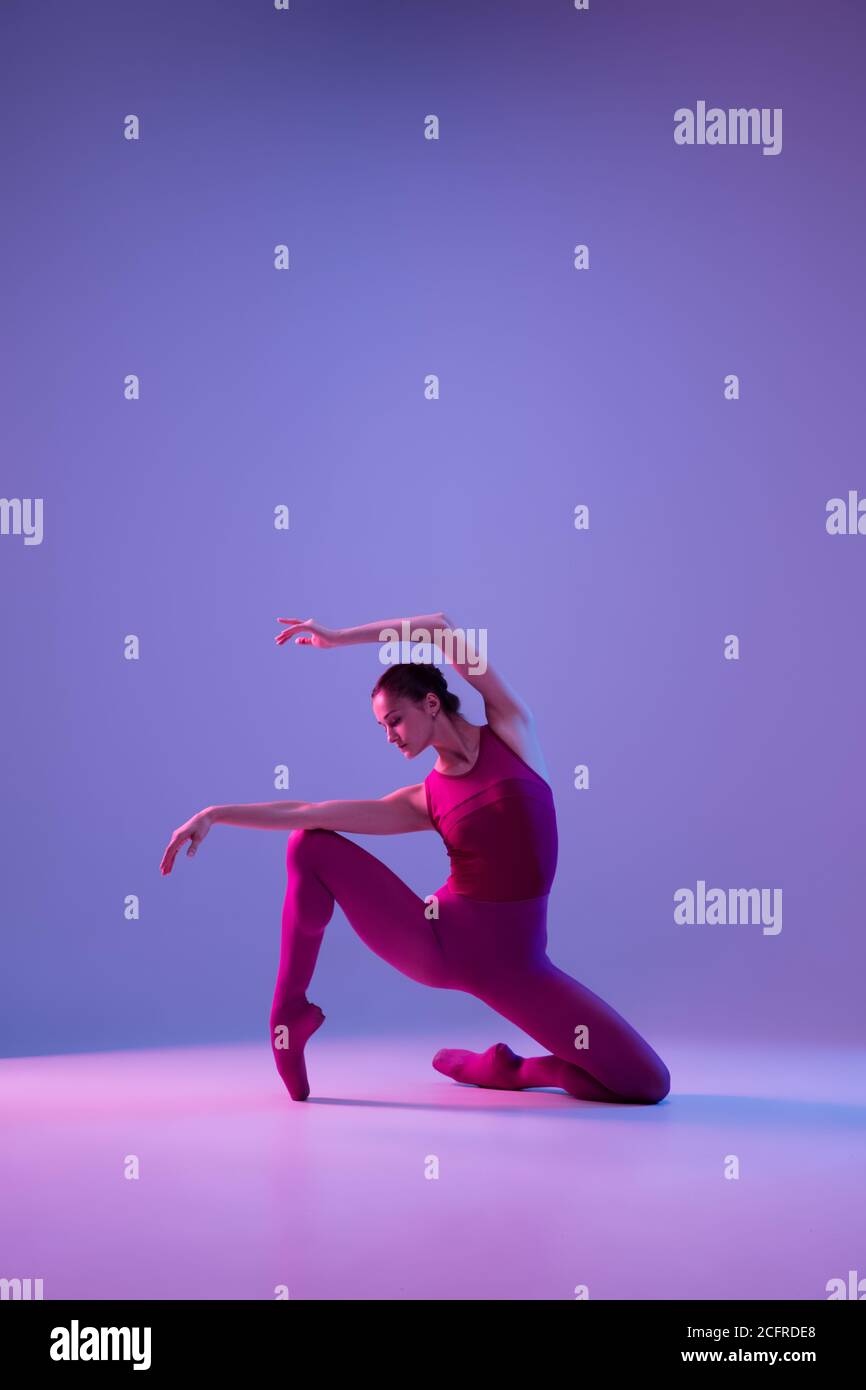 Beautiful. Young and graceful ballet dancer isolated on purple studio ...