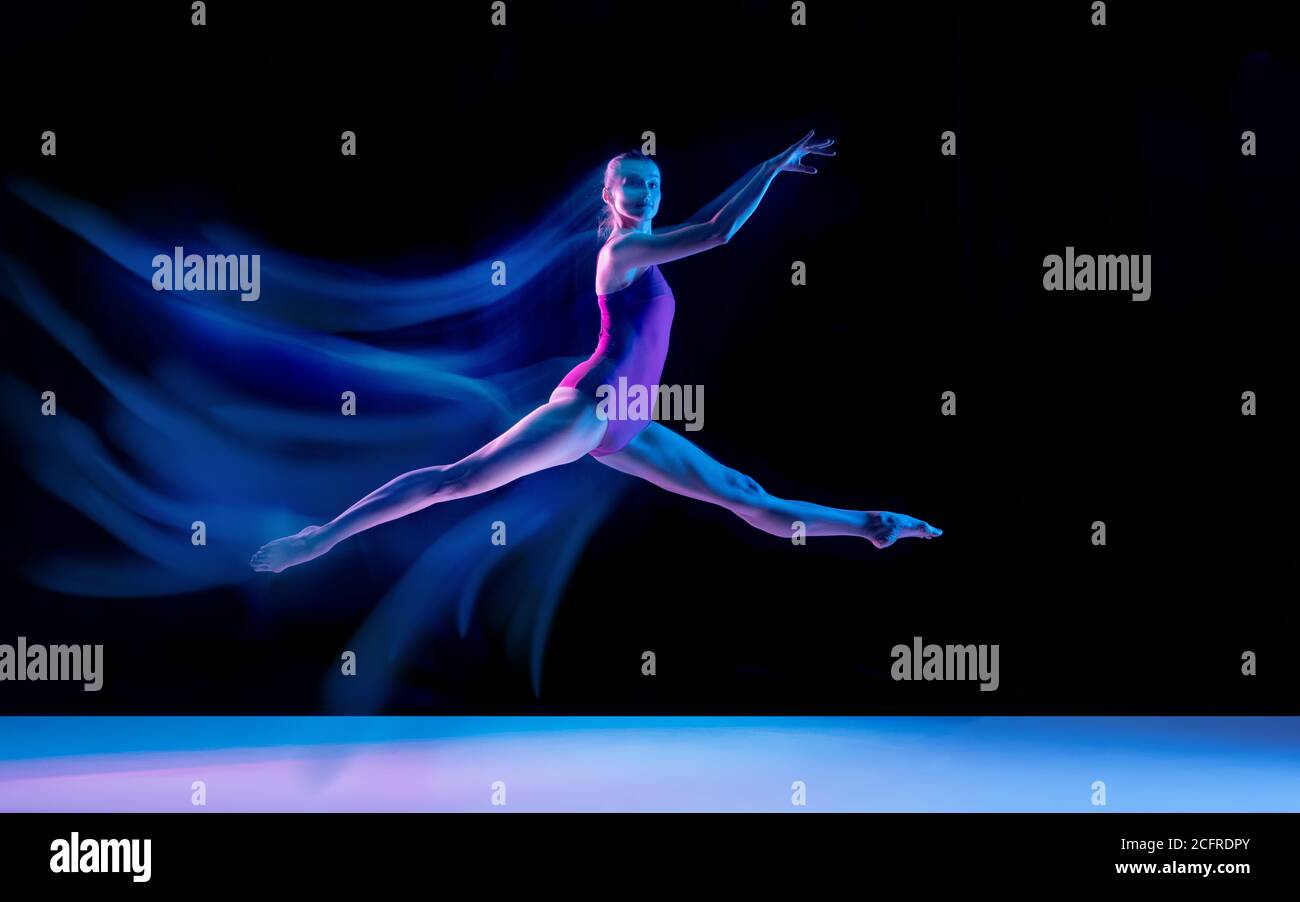 Flying bird. Young and graceful ballet dancer on black studio ...