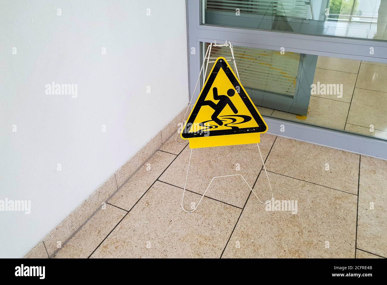 Selective focus shot of a sleepy caution sign on a wet floor Stock ...