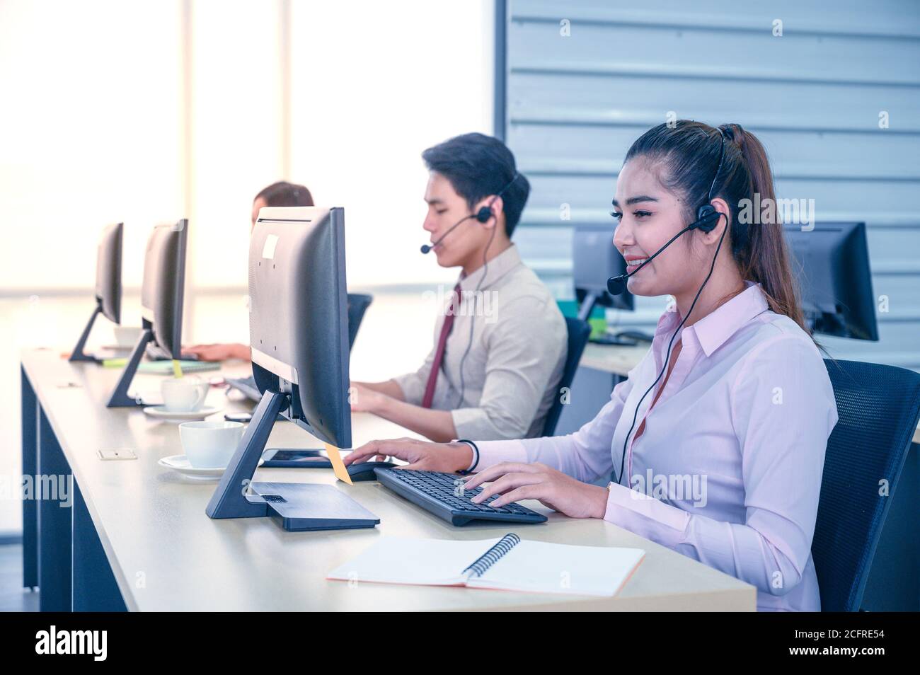Young customer service women agent with headsets and computer working at office. Professional ...