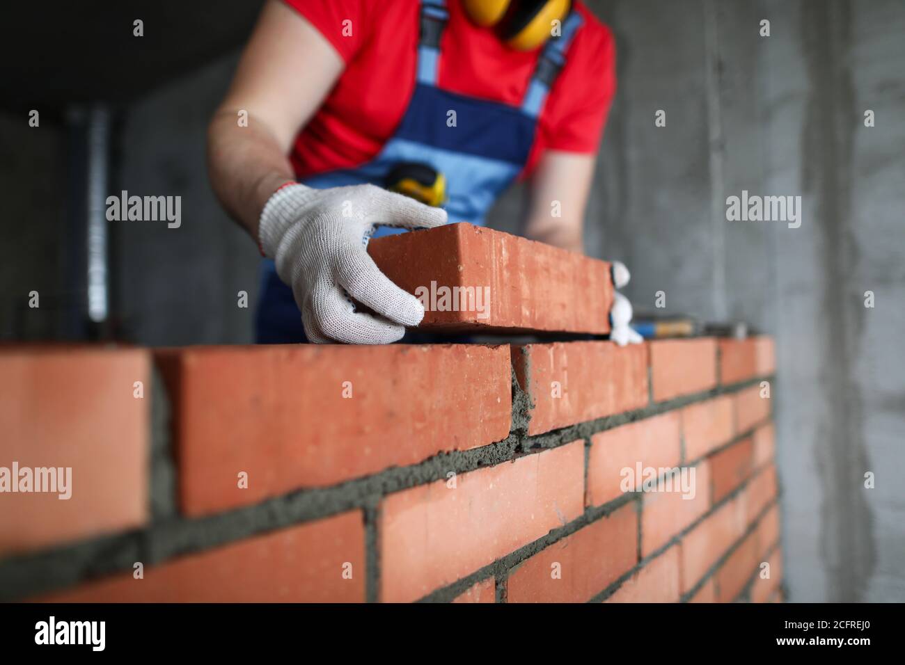 Builder makes a brick wall in a house close-up Stock Photo - Alamy