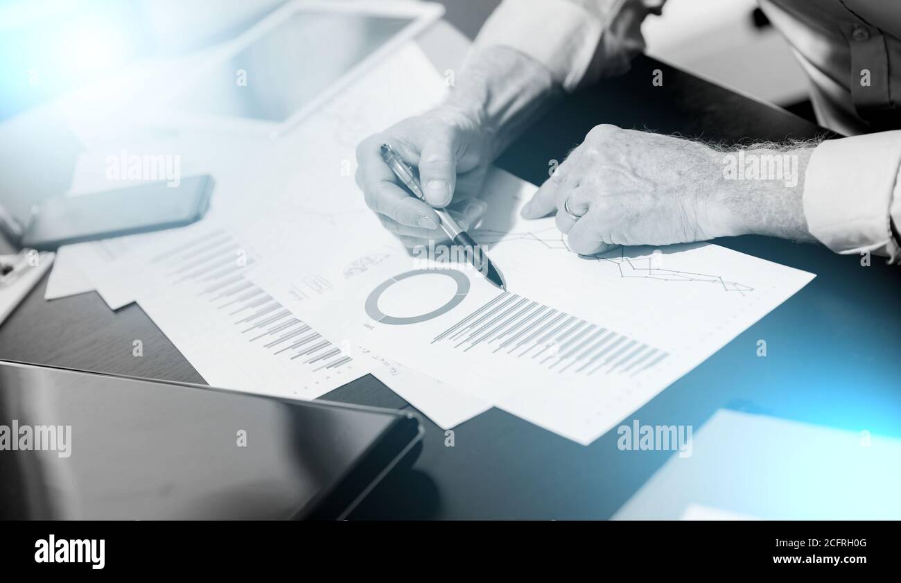 Businessman analyzing graphics at office, light effect Stock Photo - Alamy