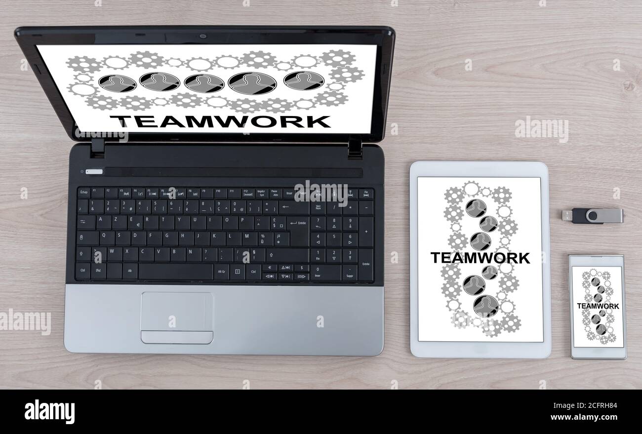 Teamwork concept shown on different information technology devices ...