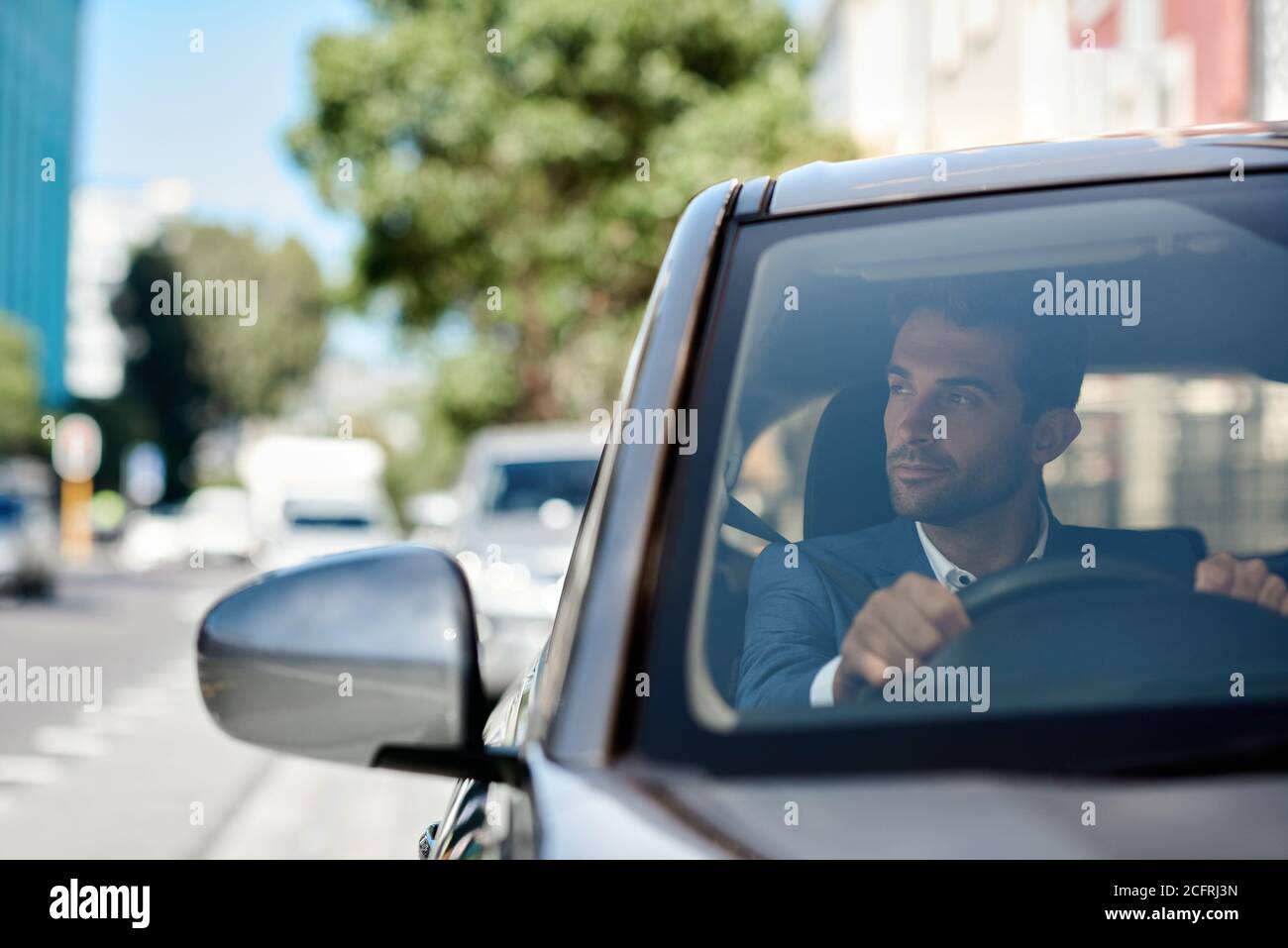 Young man driving his car through the city Stock Photo - Alamy