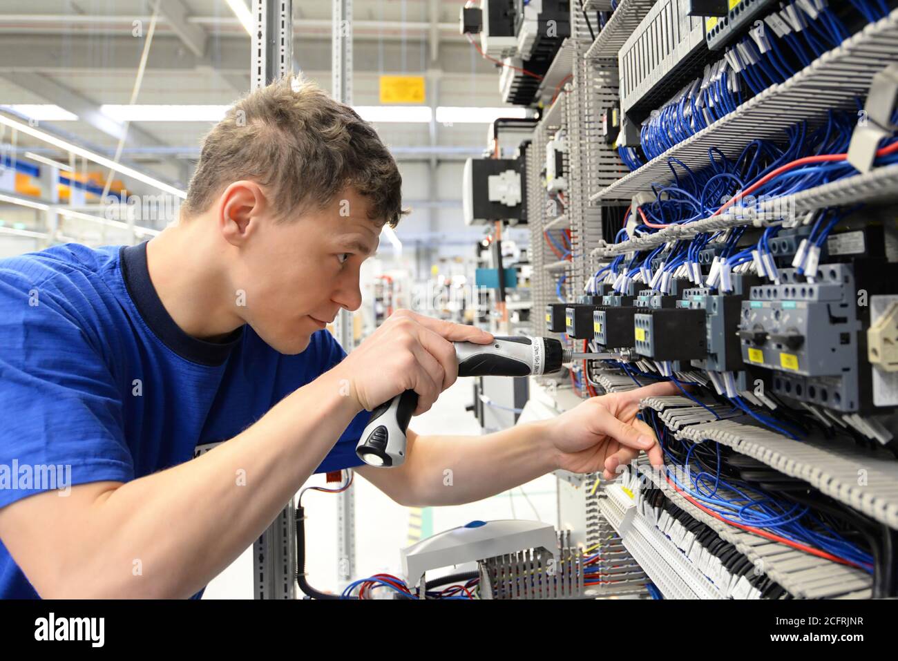 young operator assembles machine in a modern high tech factory ...