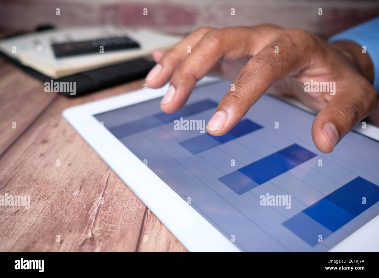 close up of businessman's hand analyzing bar chart on digital tablet ...