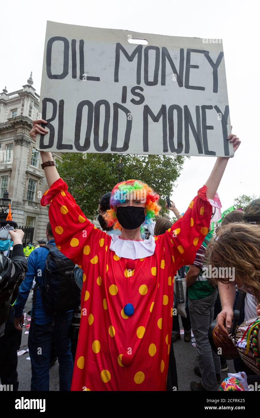 Protester in clown costume holding placard, 'Carnival of Corruption ...