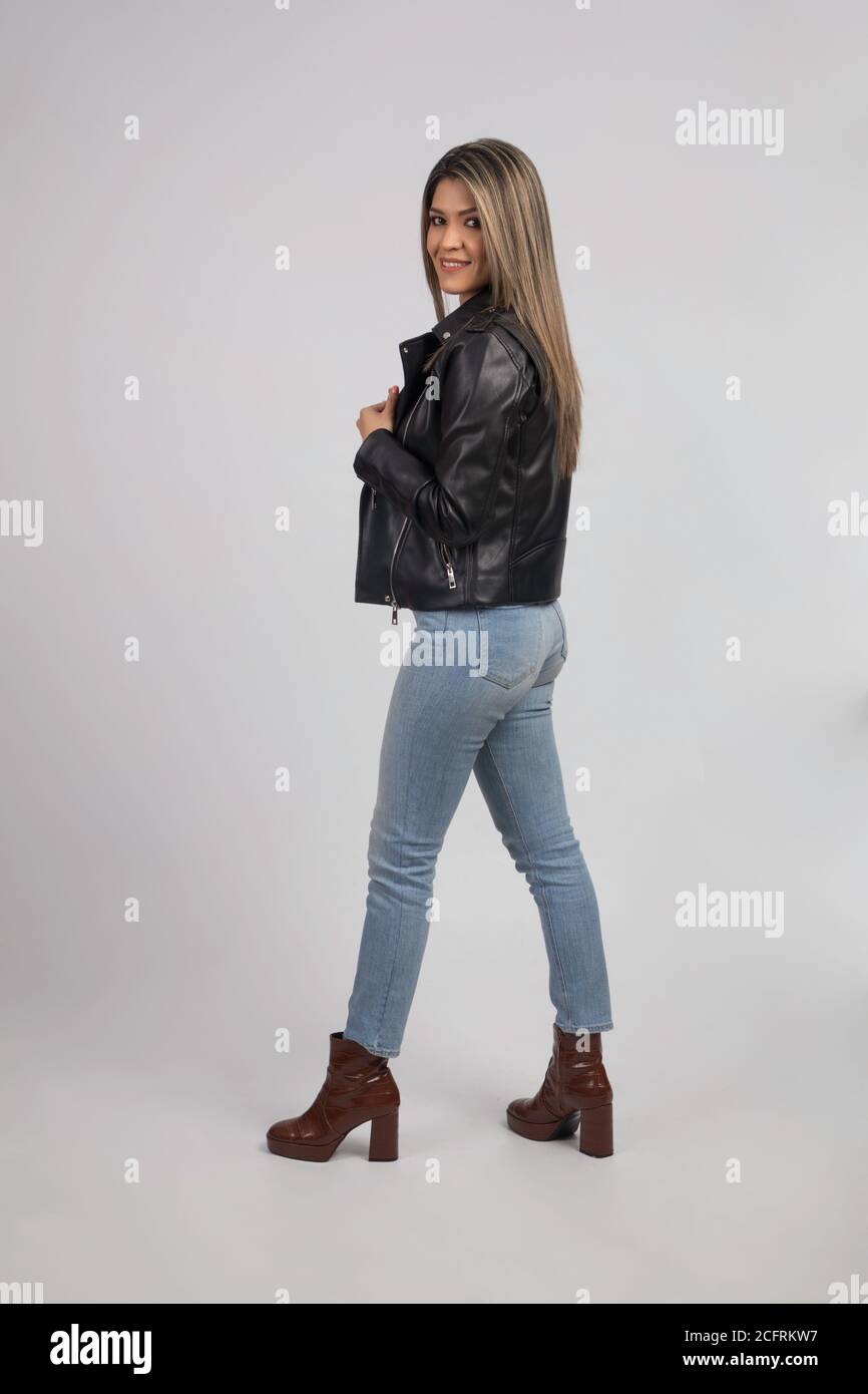 cute woman in leather jacket and jean, standing showing her back on a ...