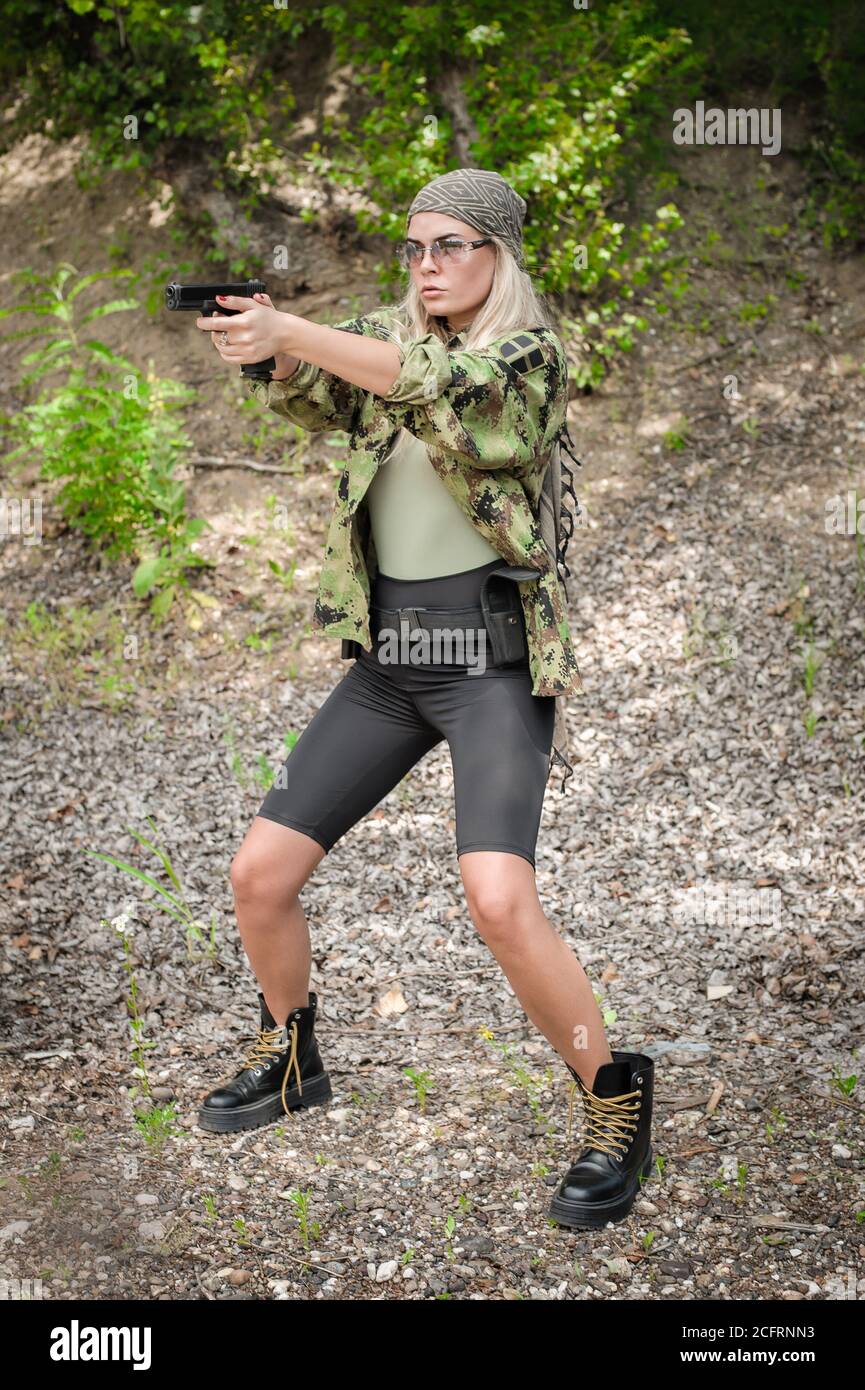 Beautiful and attractive female army soldier posing with gun. Woman ...