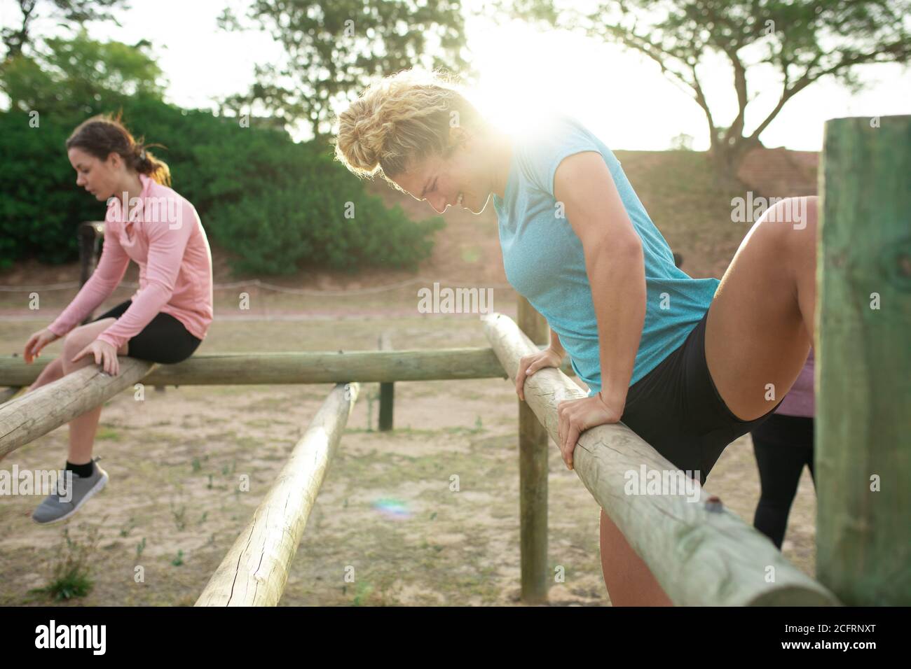 Group of woman climbing through obstacle course at boot camp Stock ...