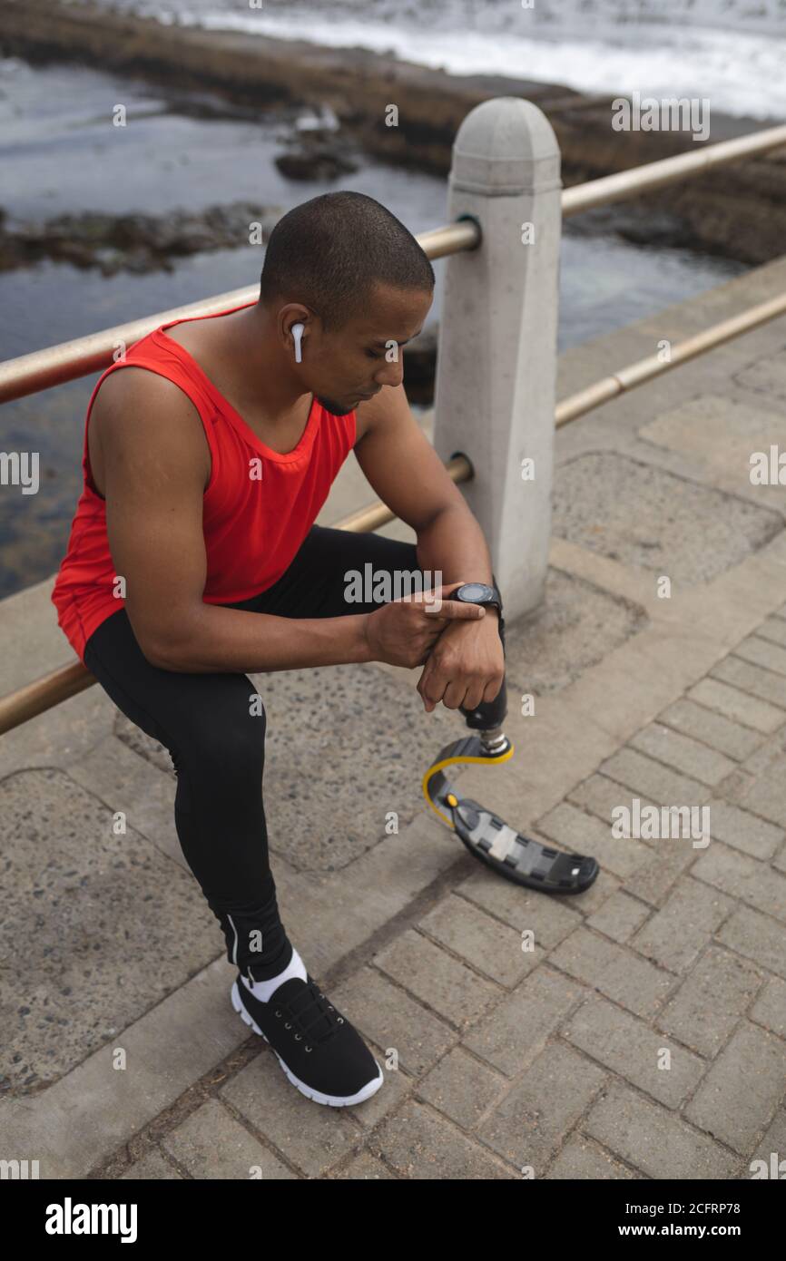 Man with prosthetic leg performing using smartwatch on the promenade ...