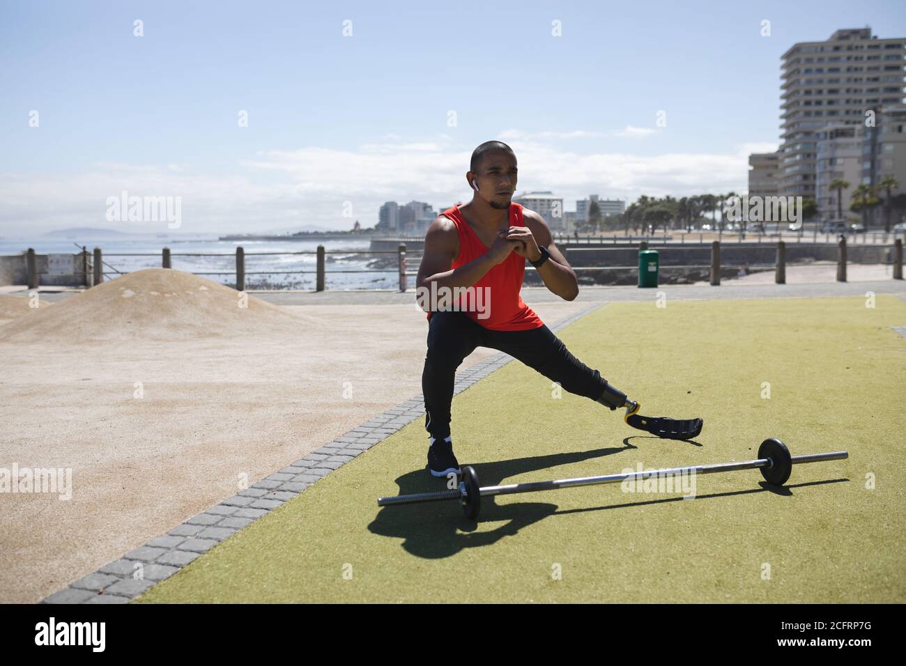 Man with prosthetic leg performing stretching exercise in the park ...