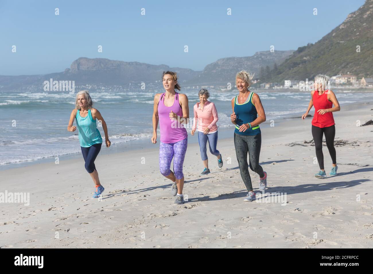Woman running on beach group hi-res stock photography and images - Alamy