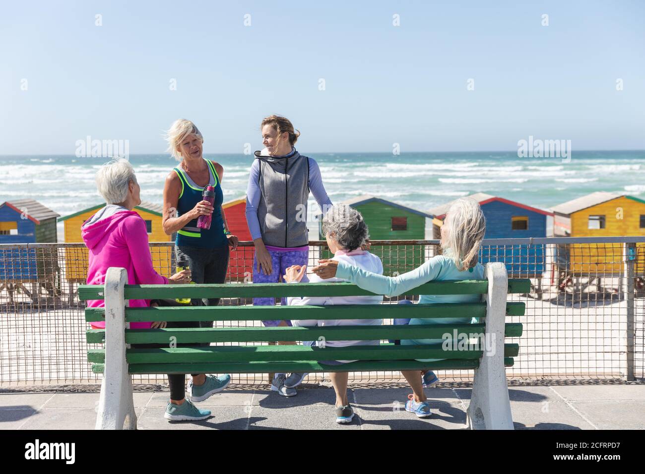 Group of woman talking while seating on the bench Stock Photo - Alamy