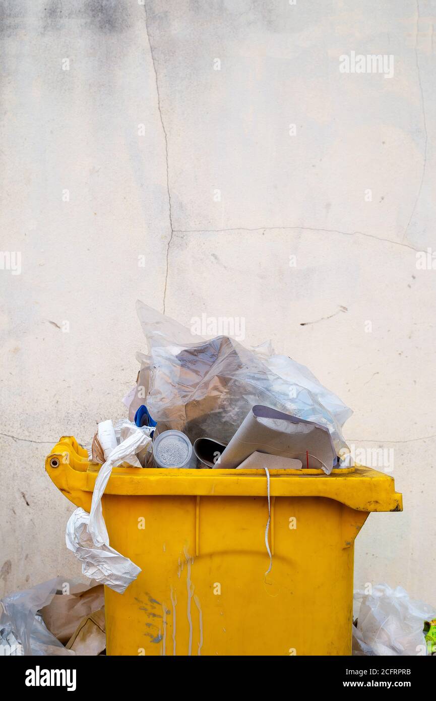 closeup yellow trash bin with soft-focus and overlight in the ...