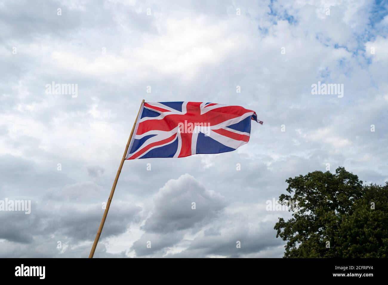 Union Jack flag flying against a cloudy sky Stock Photo - Alamy