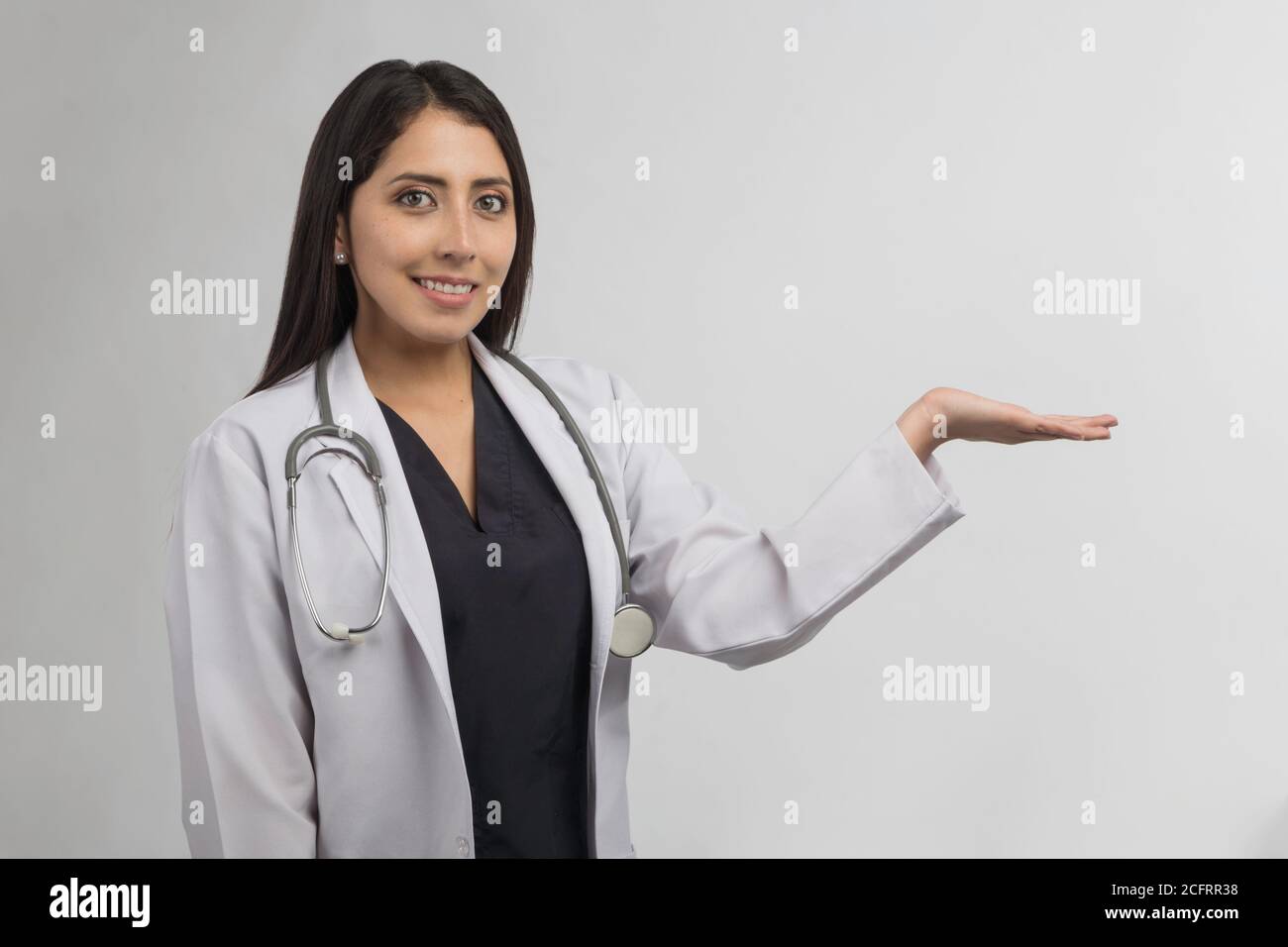 female doctor wearing a bench gown while making a sign with her hand ...