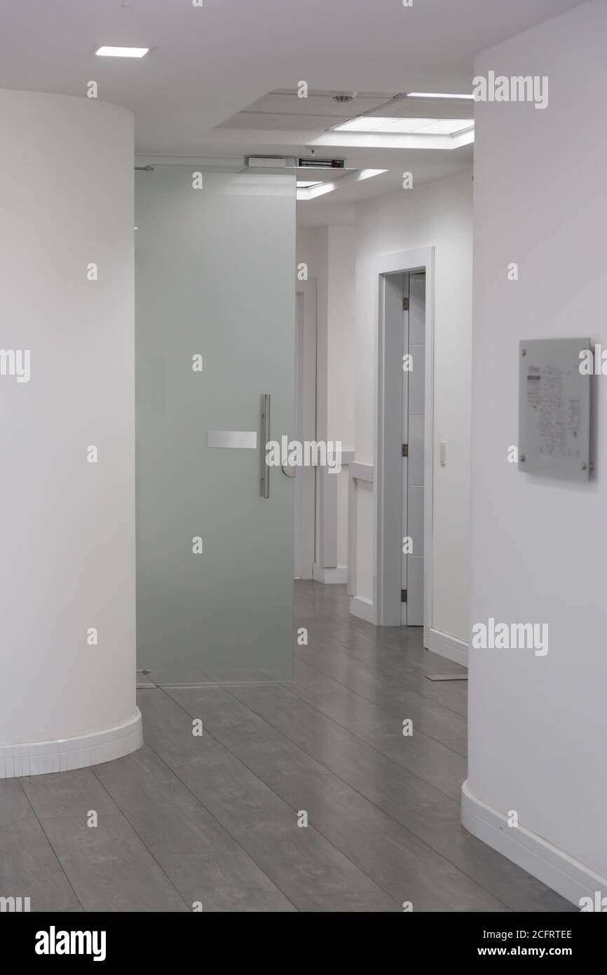 corridor with white walls with glass door, lamps and wooden floor Stock ...