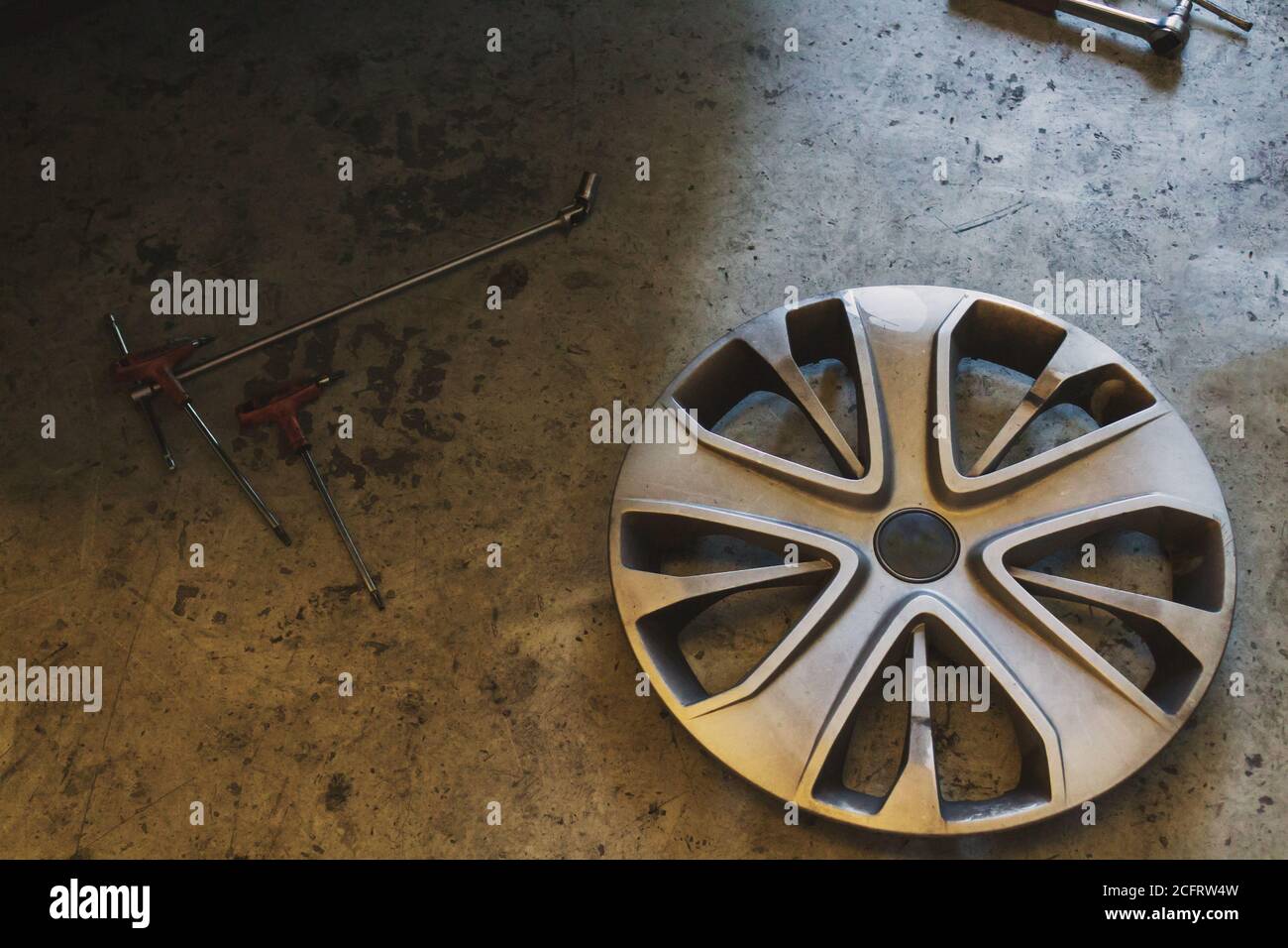 A hubcap and tools on the floor in a car service Stock Photo - Alamy