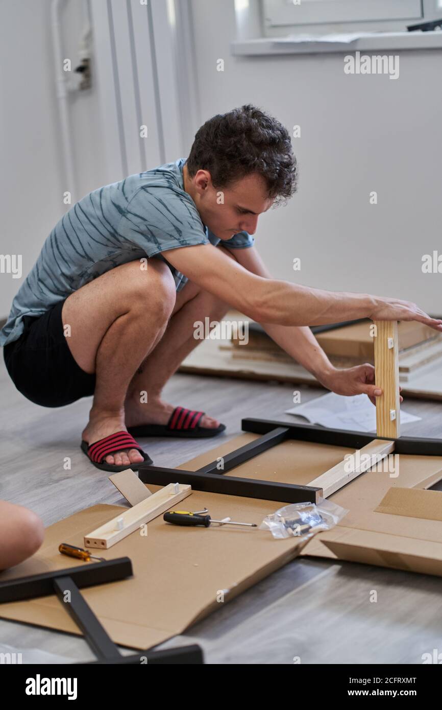 Young man assembling furniture in hi-res stock photography and images ...