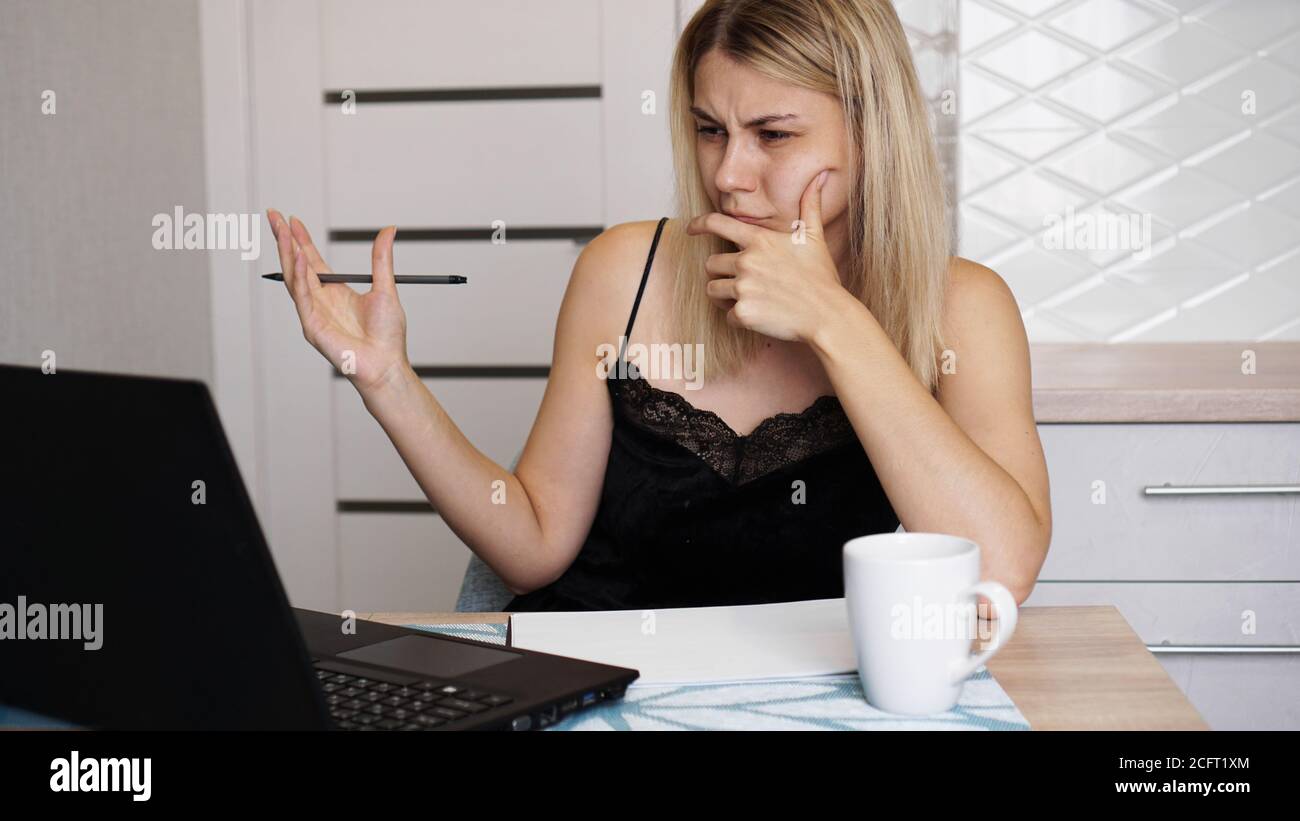 Portrait of an attractive woman at the table with cup and laptop ...
