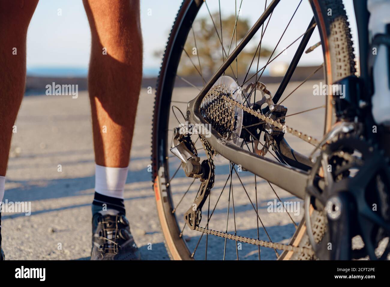 Cyclist man feet and bike wheel on coastal road Stock Photo - Alamy