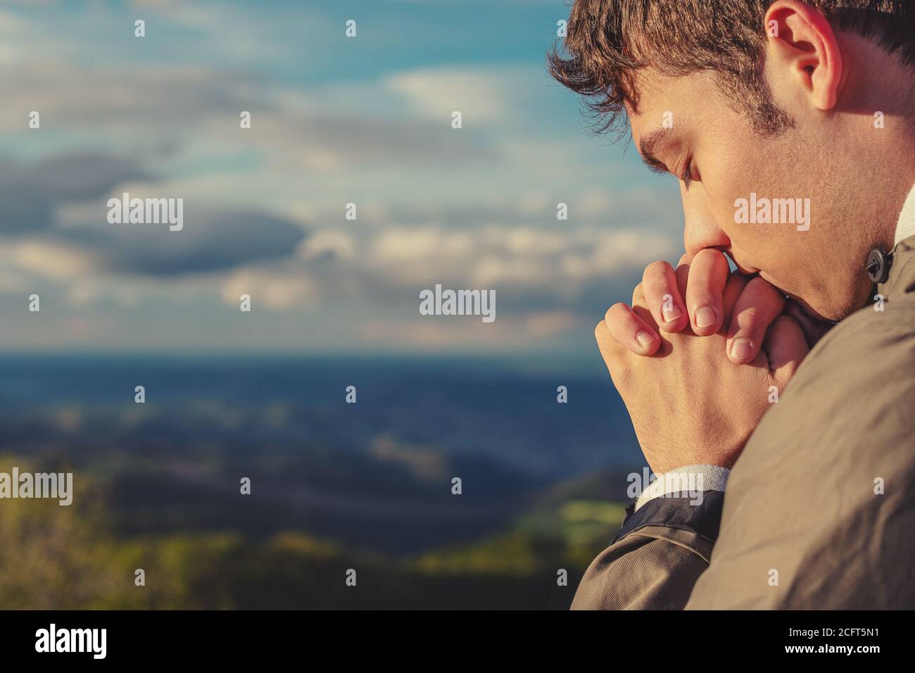 Christian worship and praise. A young man is praying and worshiping in ...