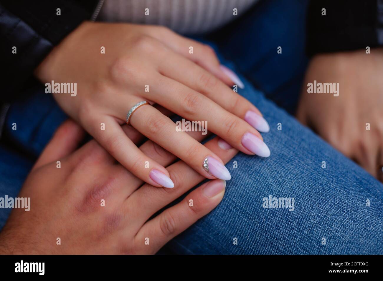 Close up black woman and man in love sitting on couch two people holding hands. Symbol sign ...