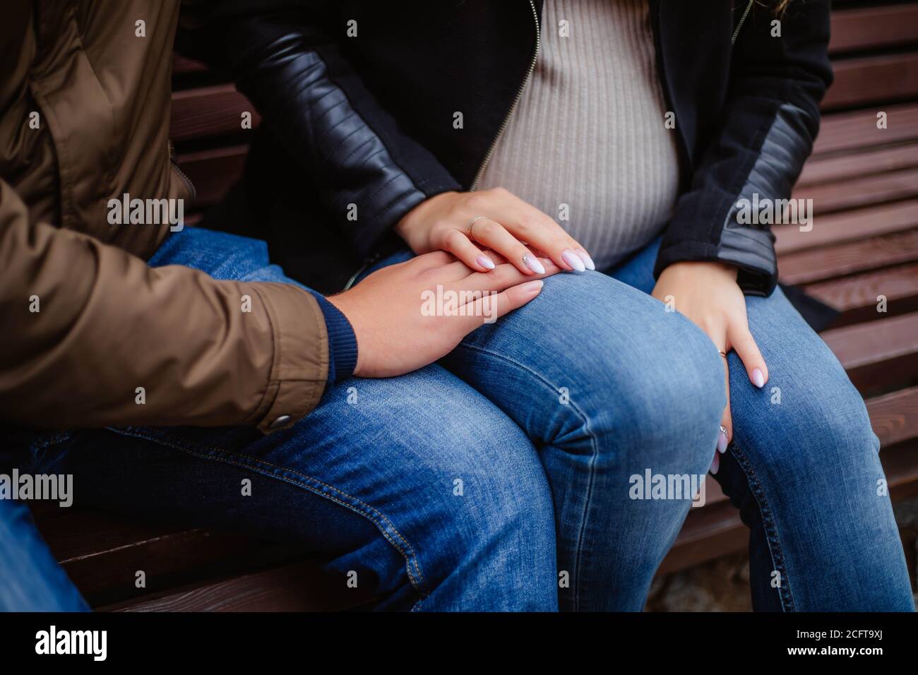 Close up black woman and man in love sitting on couch two people holding hands. Symbol sign ...