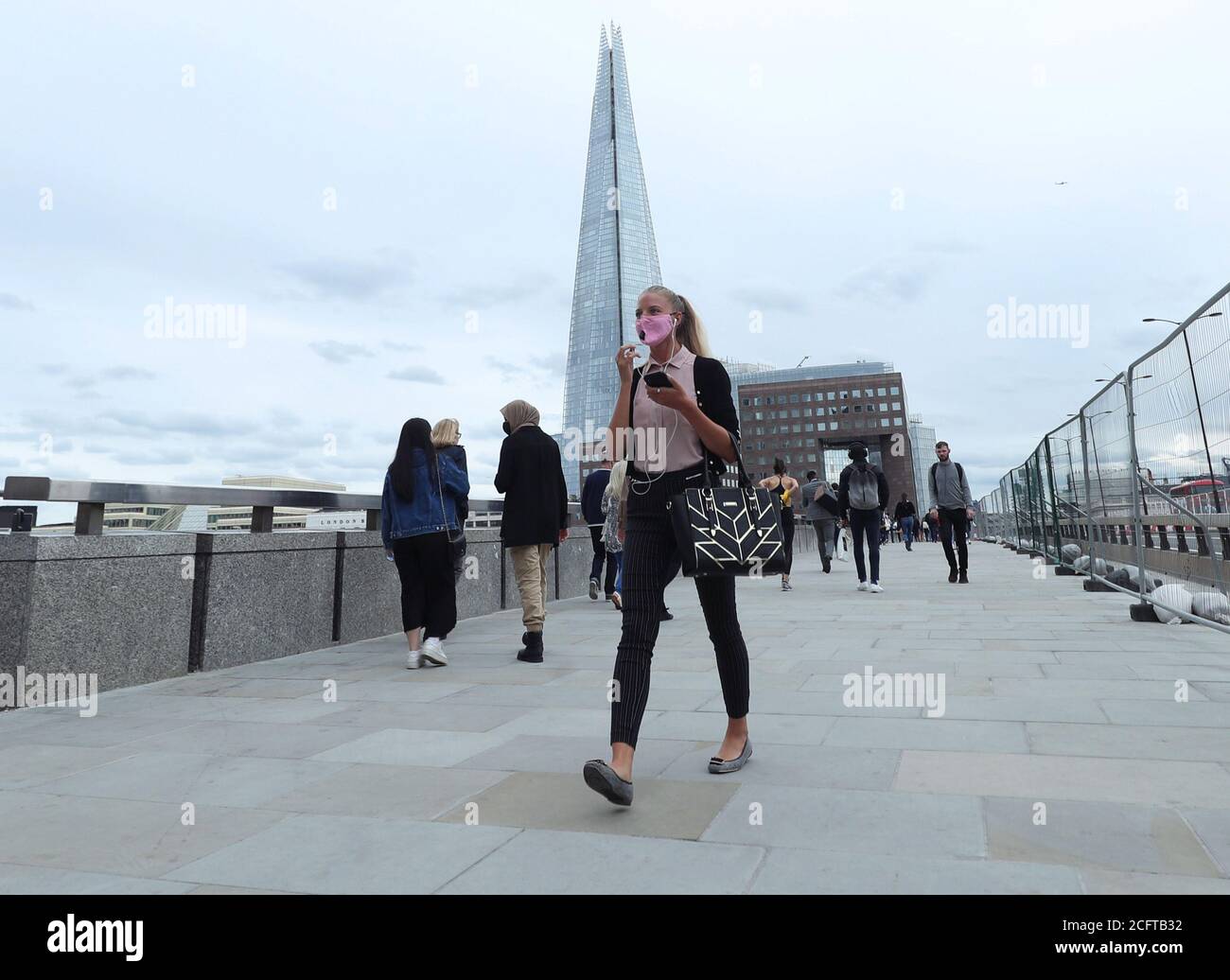 Commuters crossing London Bridge during evening rush hour. Train ...