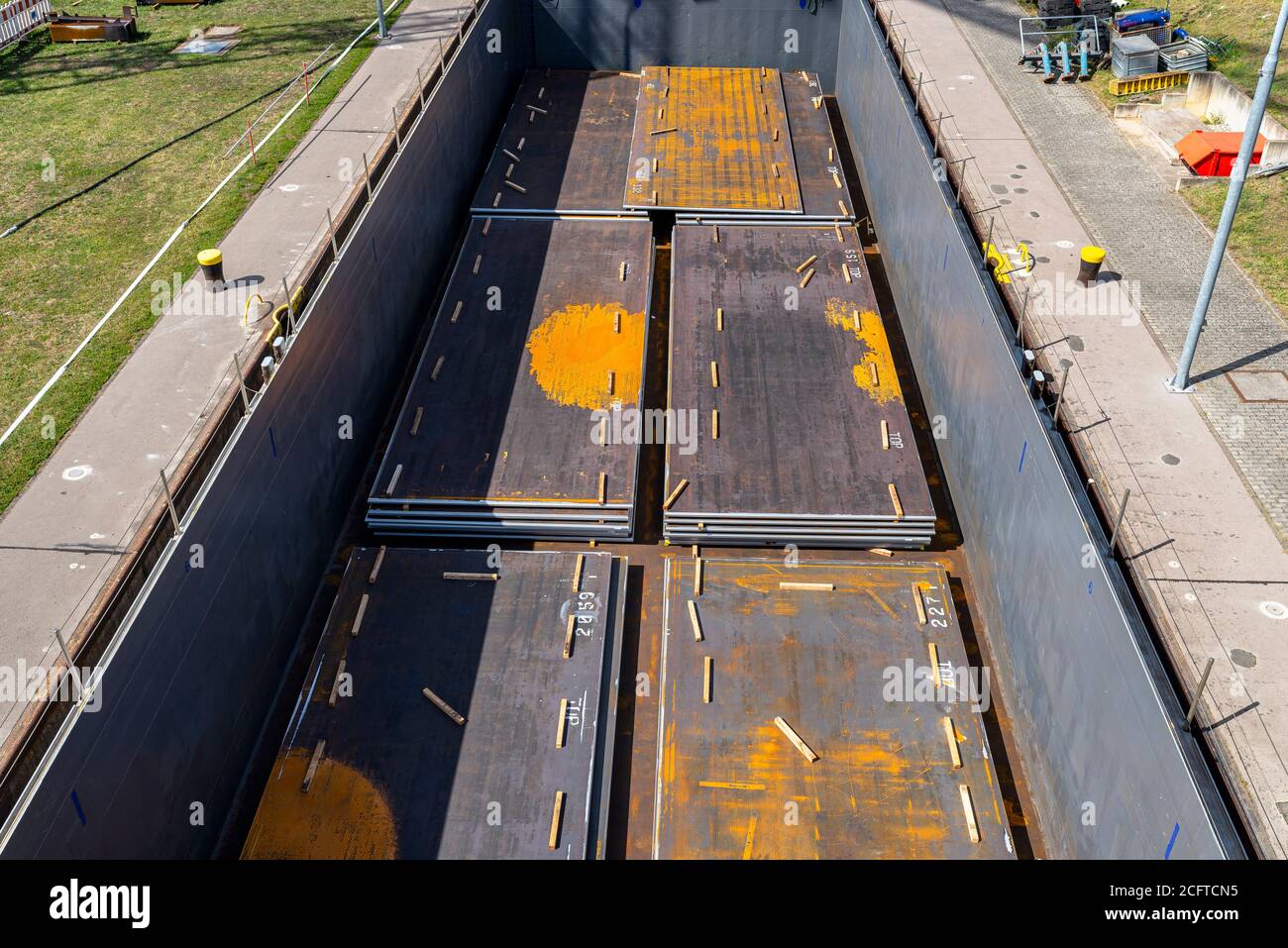 Barge filled with sheets of thick metal, flowing into the river lock ...