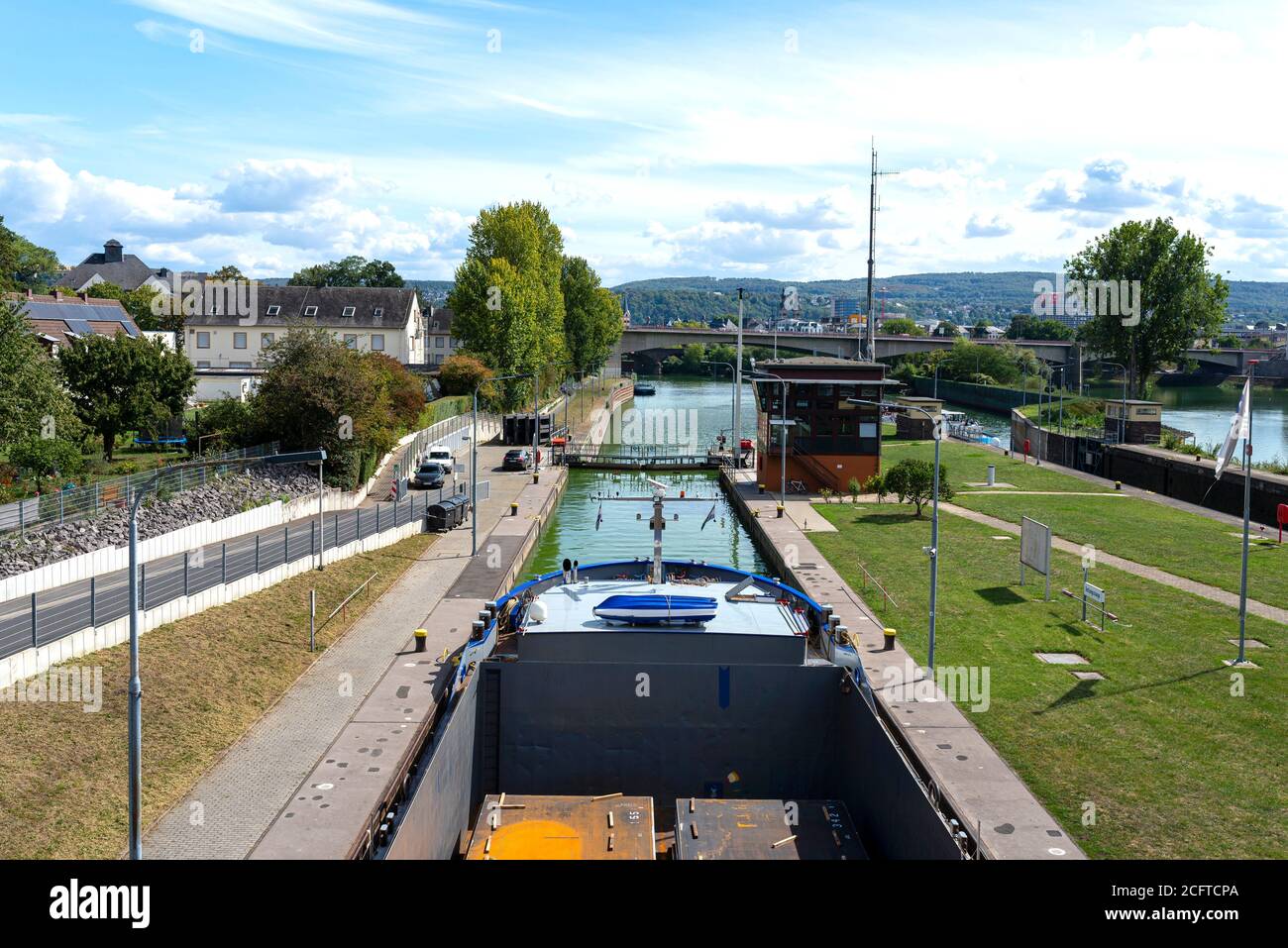 Double barge filled with sheets of thick metal, flowing into the river ...