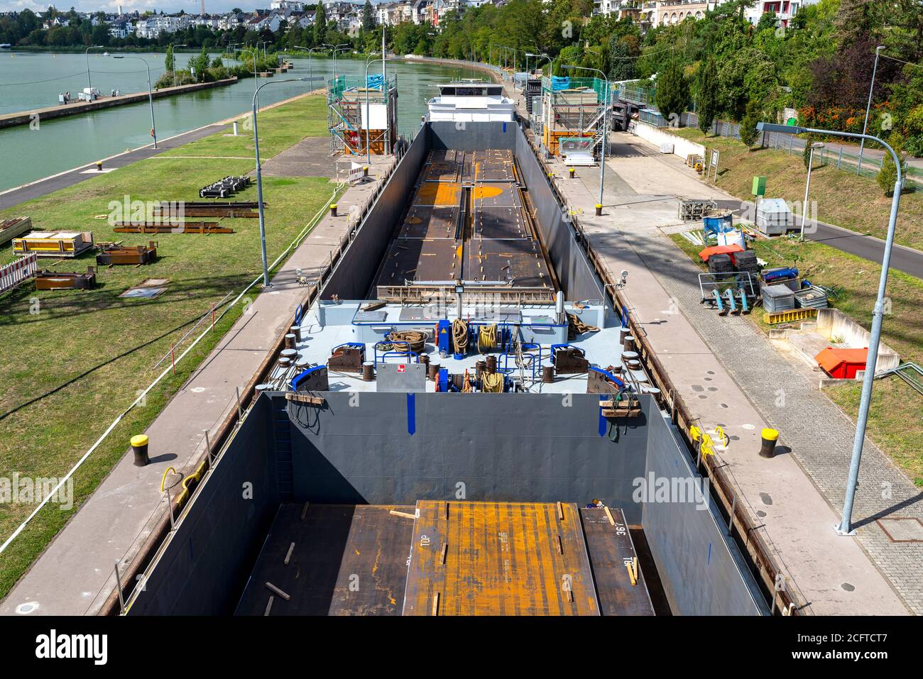 Double barge filled with sheets of thick metal, flowing into the river ...