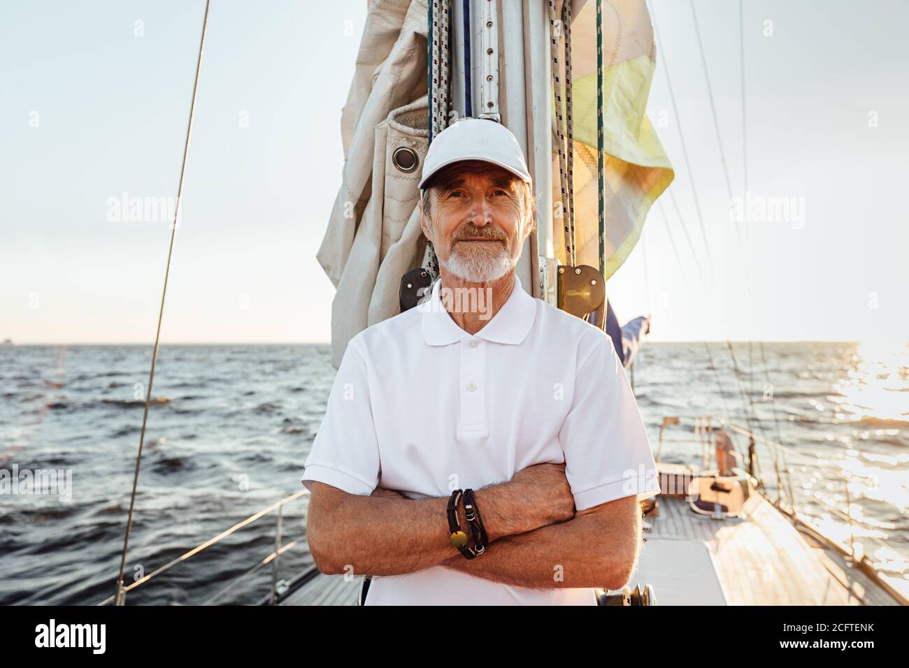 Portrait of a mature confident captain standing on his yacht at mast ...