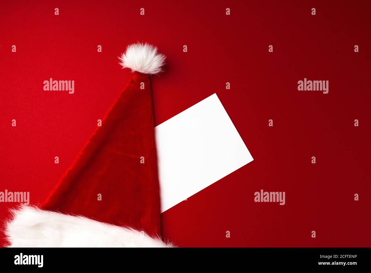 Santa Claus hat on red background top view Stock Photo - Alamy