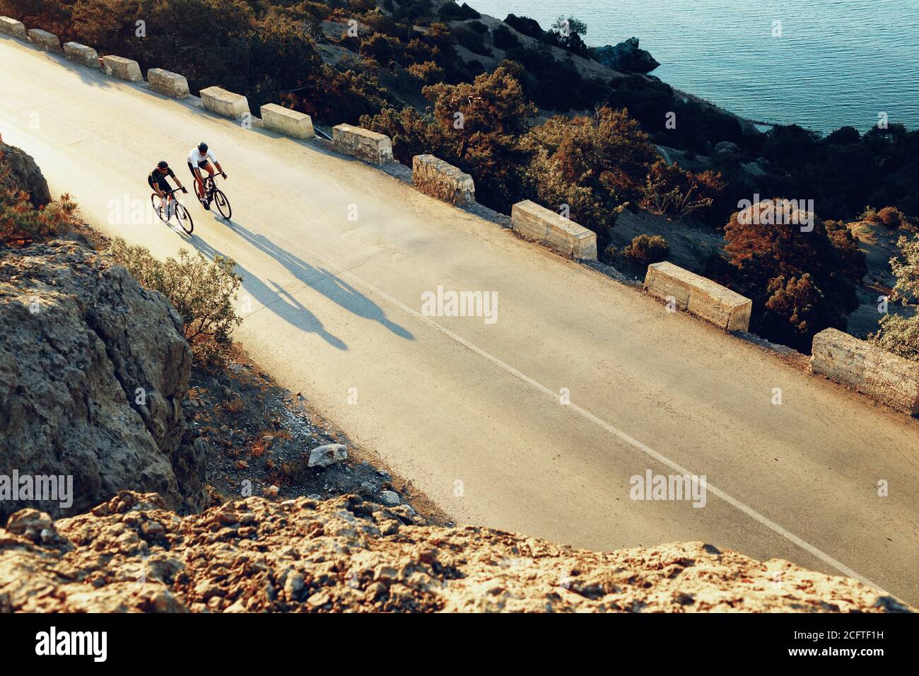 Two professional male cyclists riding their racing bicycles in the ...
