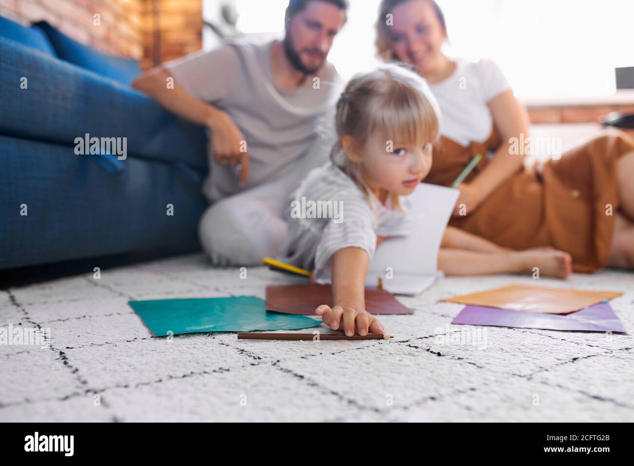 relaxed happy parents sit with daughter on the floor, caucasian little ...