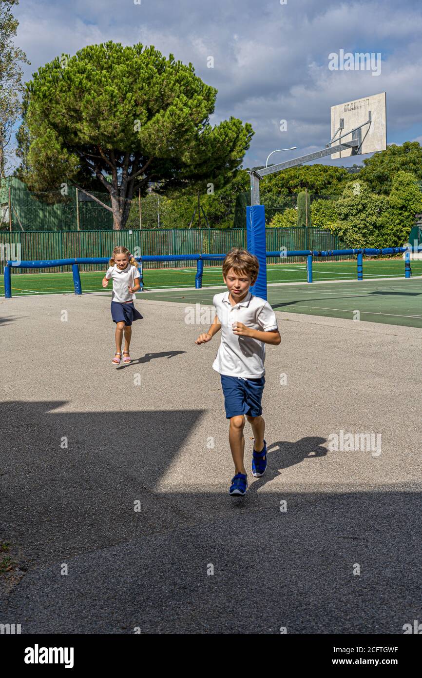 Elementary school kids having fun in school playground. Girl and boy ...