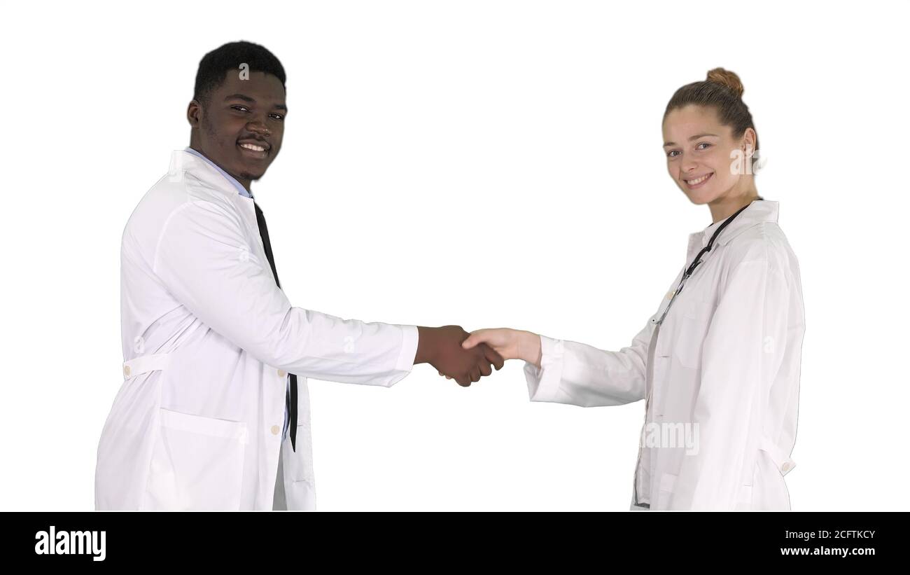 Doctors shaking hands and posing to camera on white background Stock ...