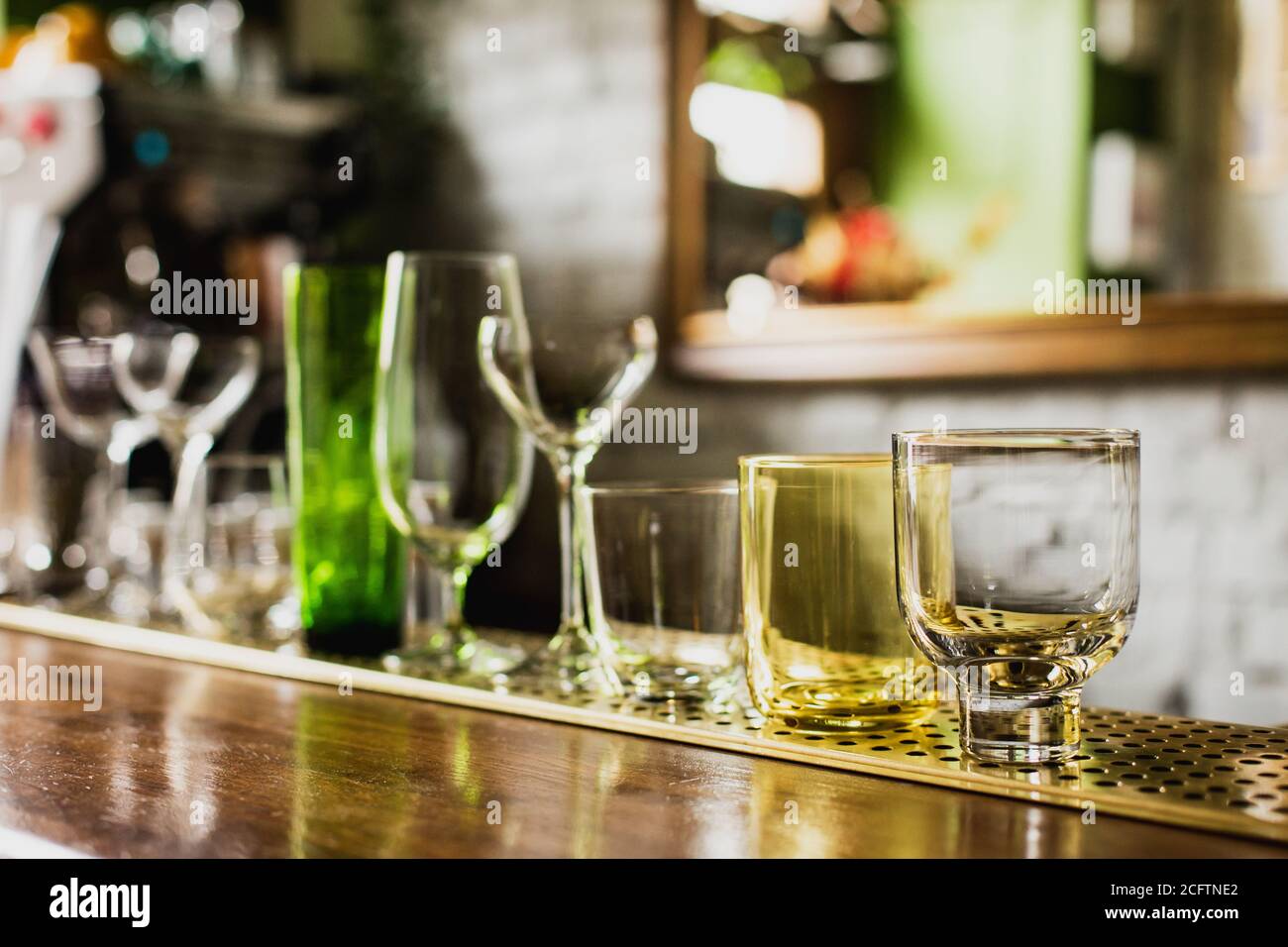 Different kinds of glasses on a bar counter, rocks, old fashioned ...