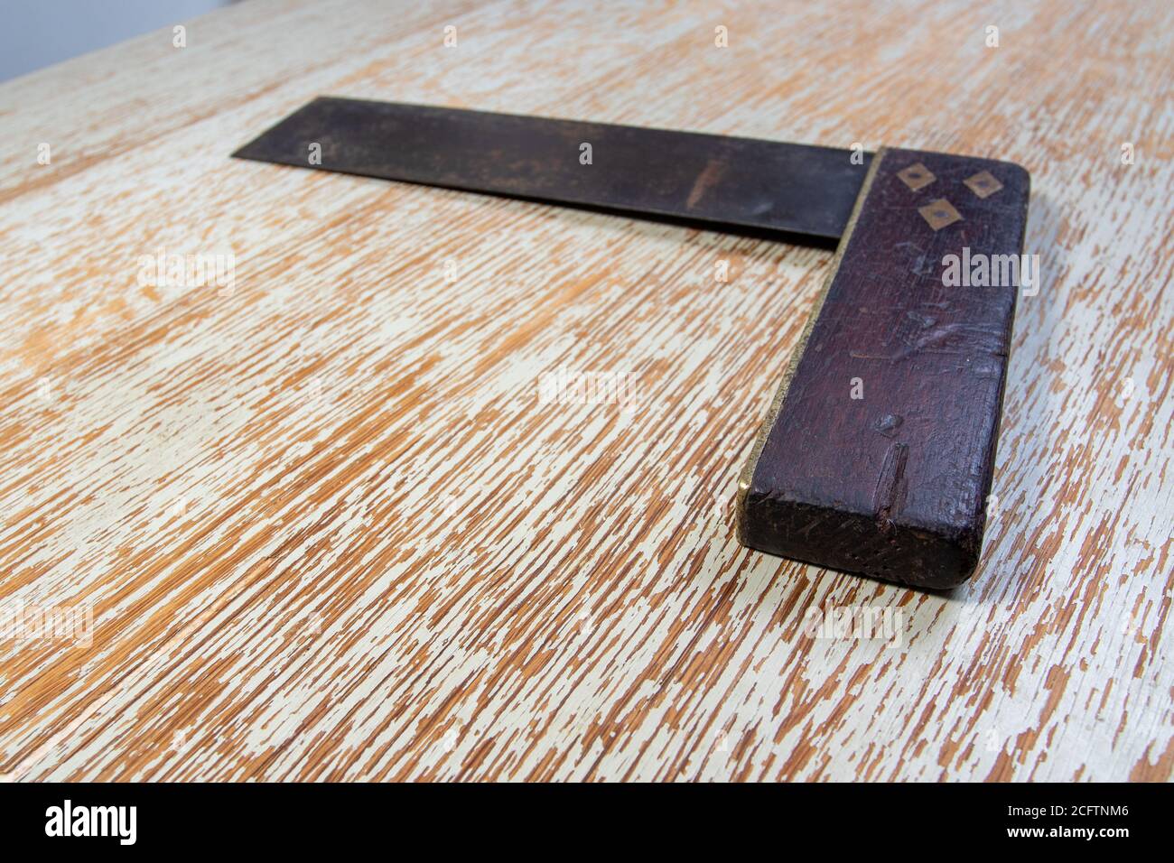 Vintage carpenter's square of dark wood and brass Stock Photo - Alamy