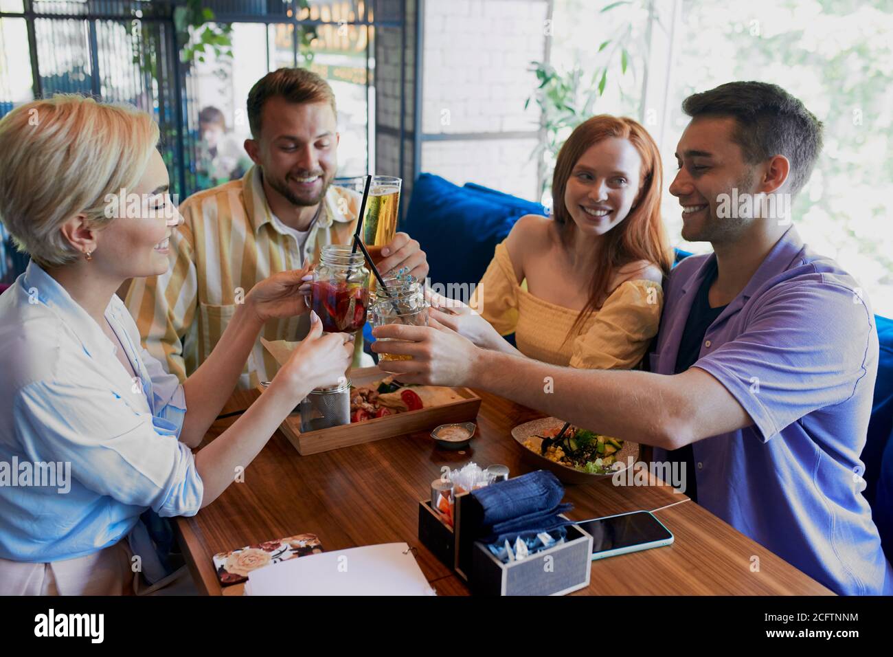 two married couples got together in a restaurant, spend free time in ...