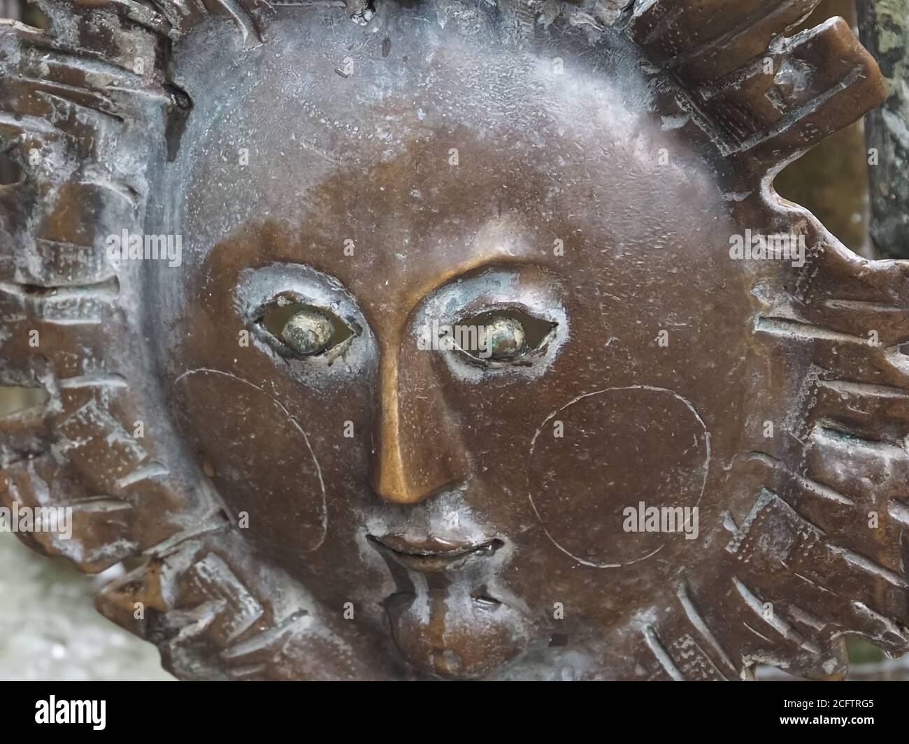Bronze face mask at a fountain Stock Photo - Alamy