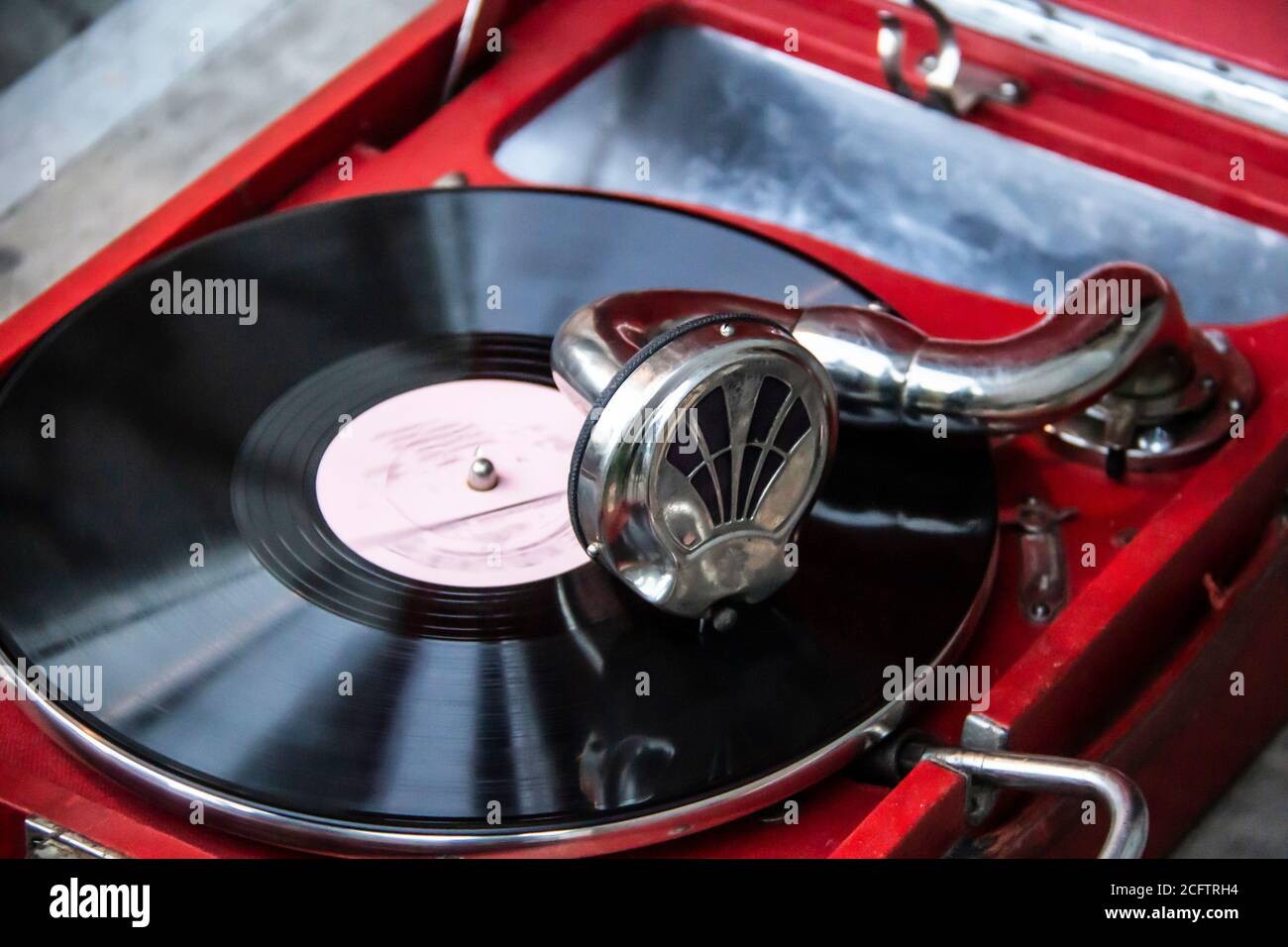 Old red vintage record player with vinyl record. Old style to listen ...