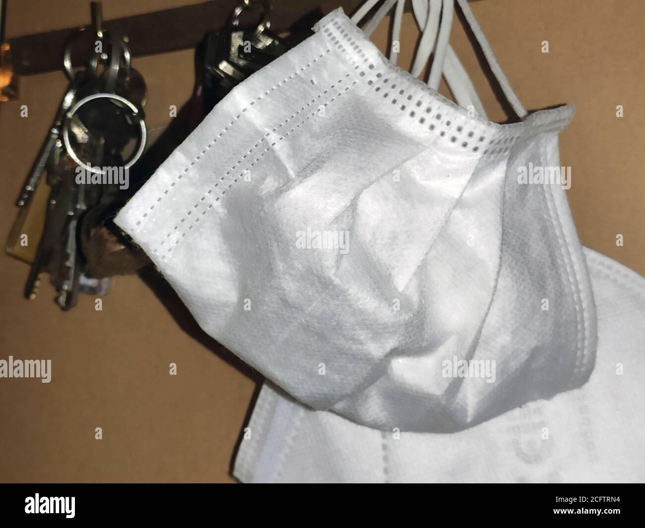 New normal - medical face masks hanging on the wall with keys Stock ...