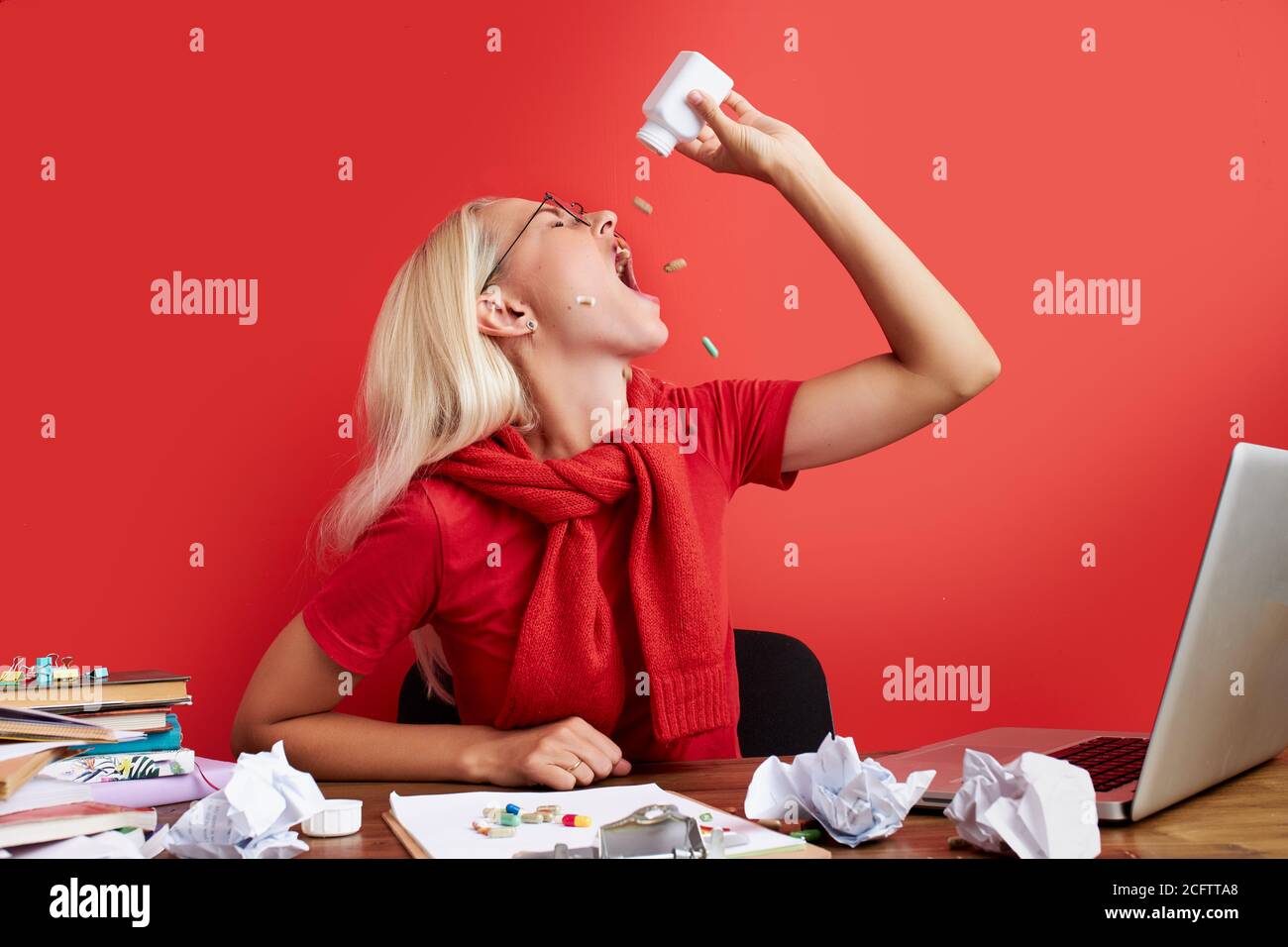 young blonde female take medicine at work, has stress, sit with papers ...