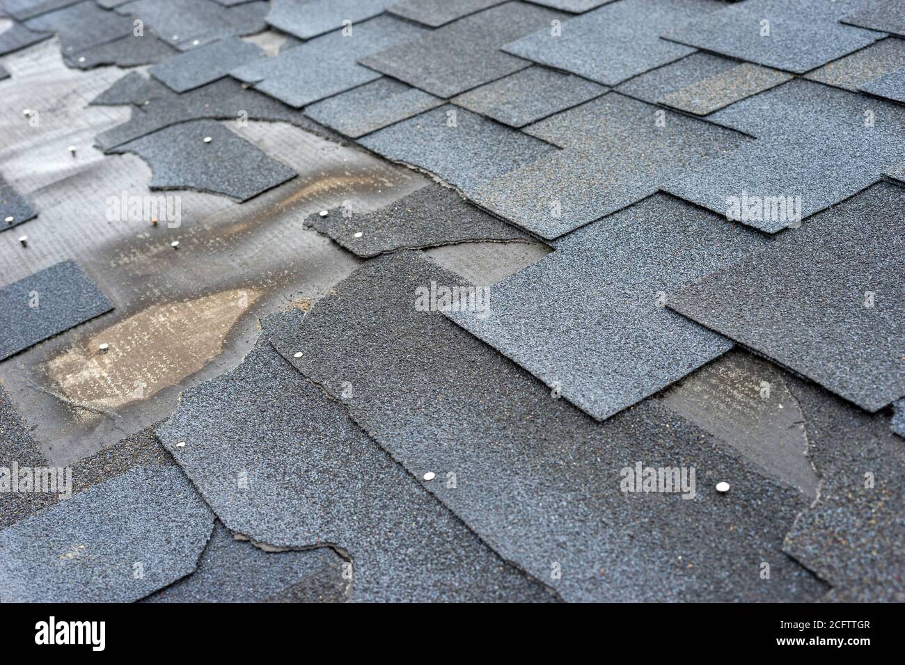 Сlose up view of bitumen shingles roof damage that needs repair Stock ...
