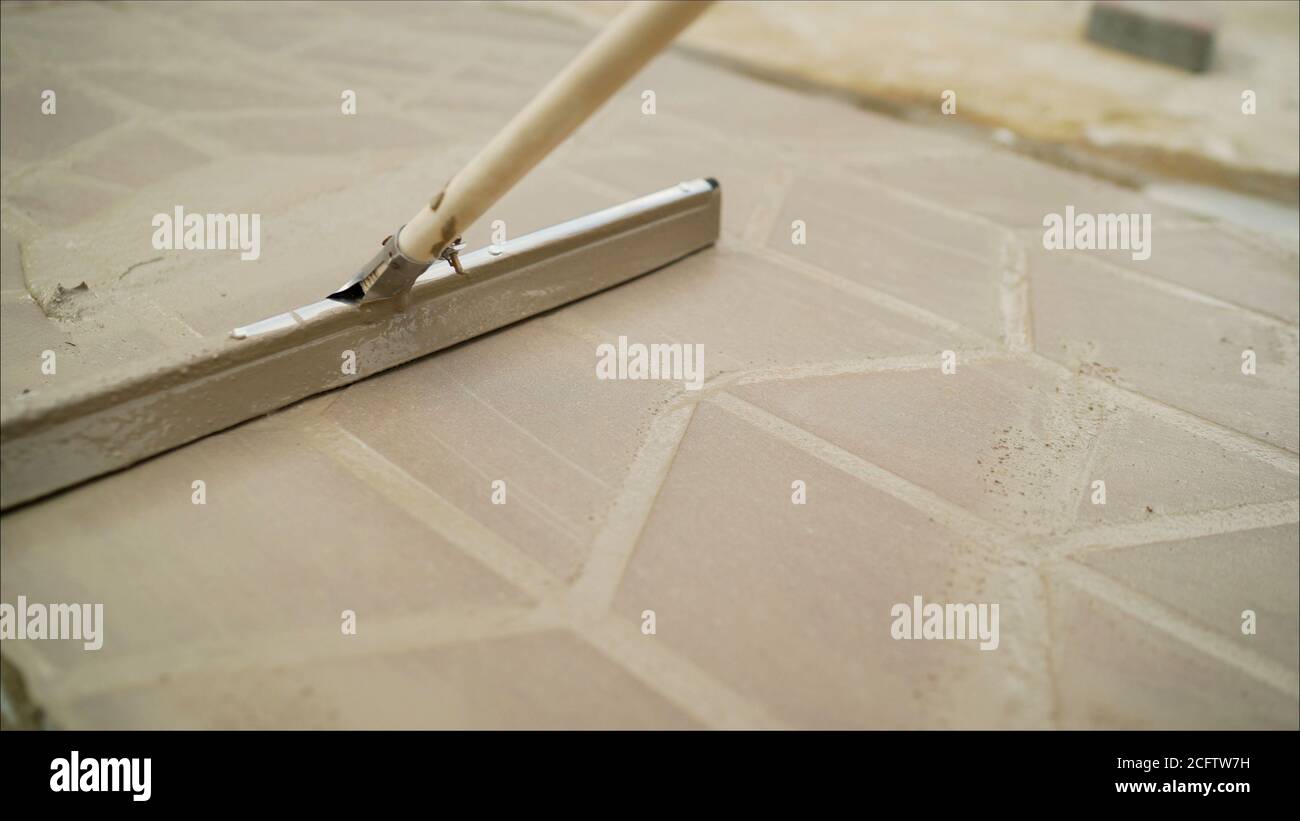 Worker hand with bucket pouring cement for tiles installation making on ...